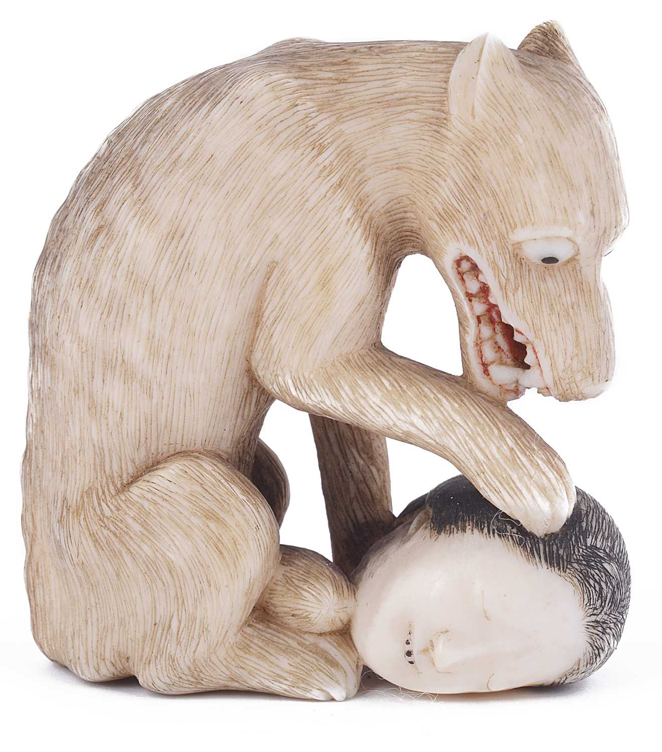 Lot 133 - ~STAINED IVORY NETSUKE OF A WOLF WITH