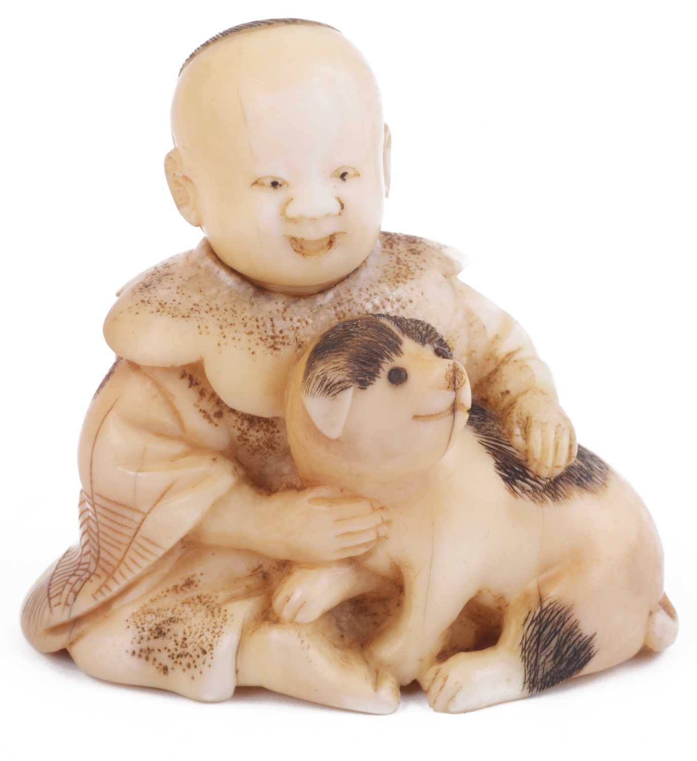 Lot 151 - ~STAINED WALRUS IVORY NETSUKE OF A BOY