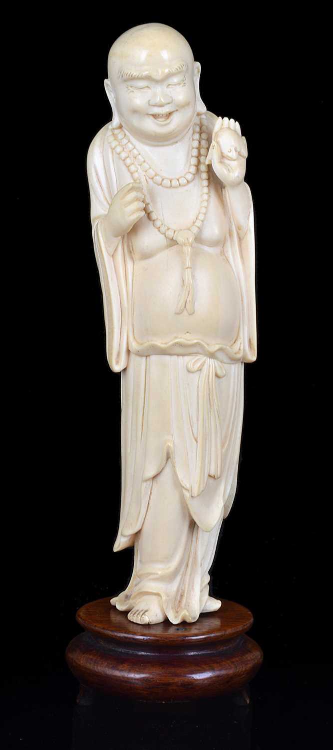 Lot 135 - A JAPANESE IVORY OKIMONO OF HOTEI
