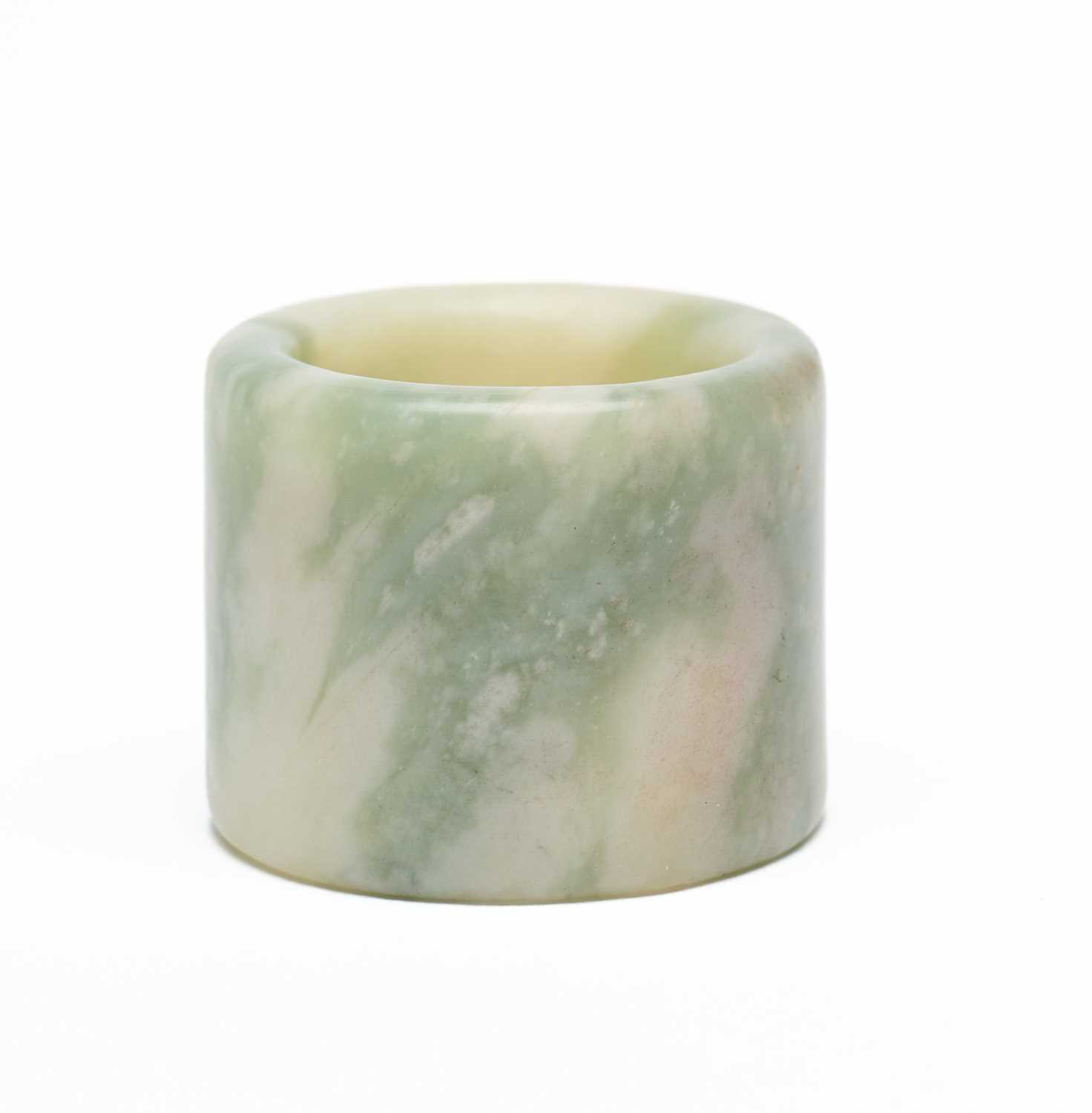 Lot 79 - A CHINESE GREEN AND WHITE STONE ARCHERS RING,